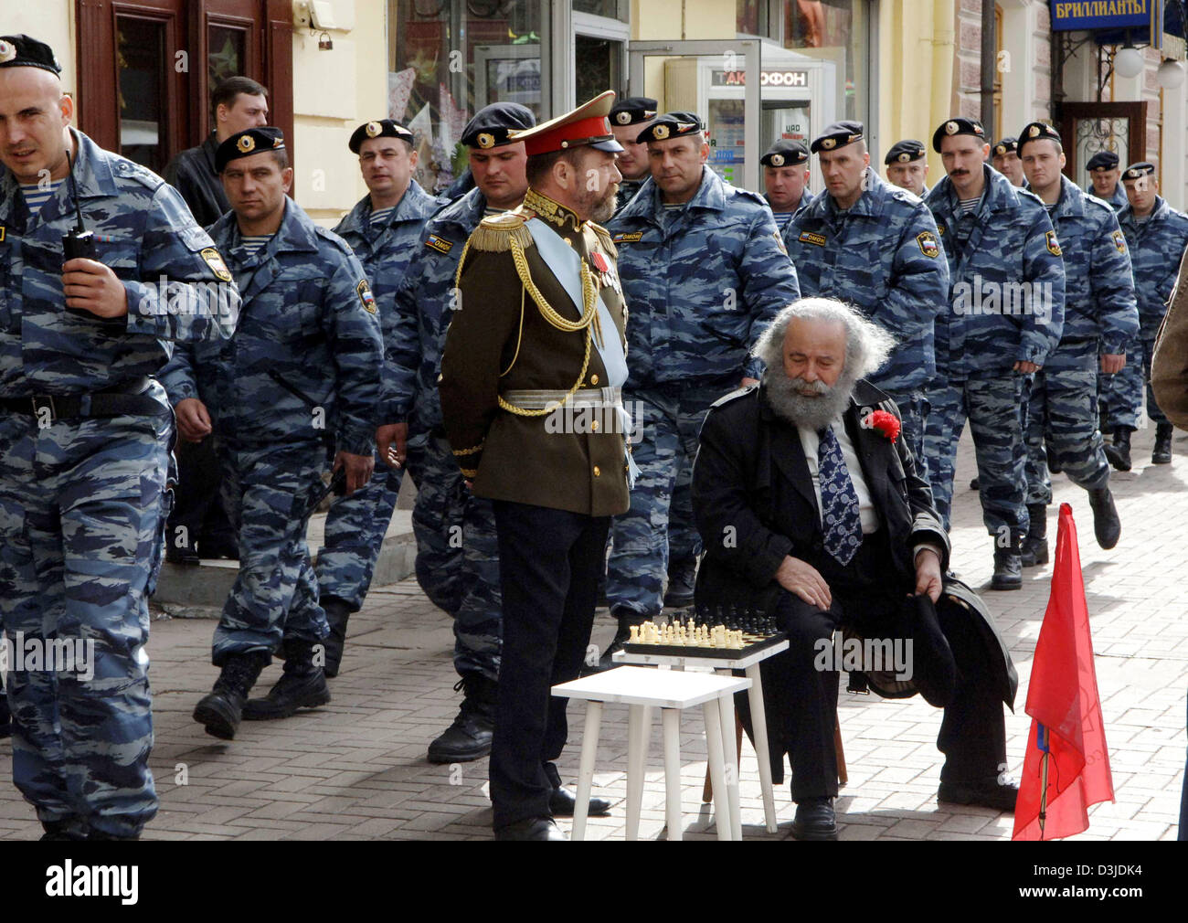 (dpa) - Russian security forces march past two men, one dressed in a ...
