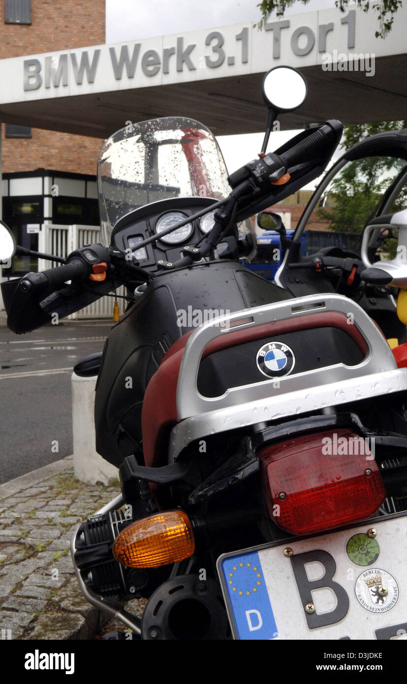 (dpa) - A BMW motorcycle stands parked in front of the factory gate of ...
