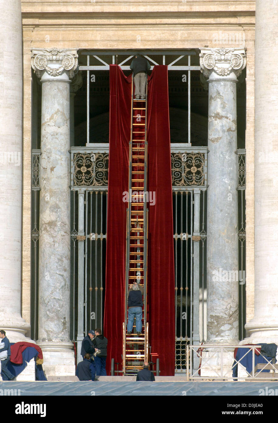 (dpa) - A huge red curtain gets fixed at the entrance to St. Peter's ...