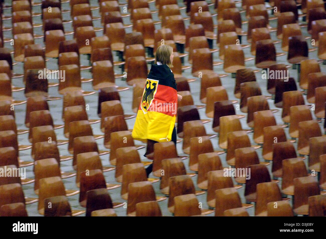 (dpa) - A German pilgrim, wearing the German national flag over her ...