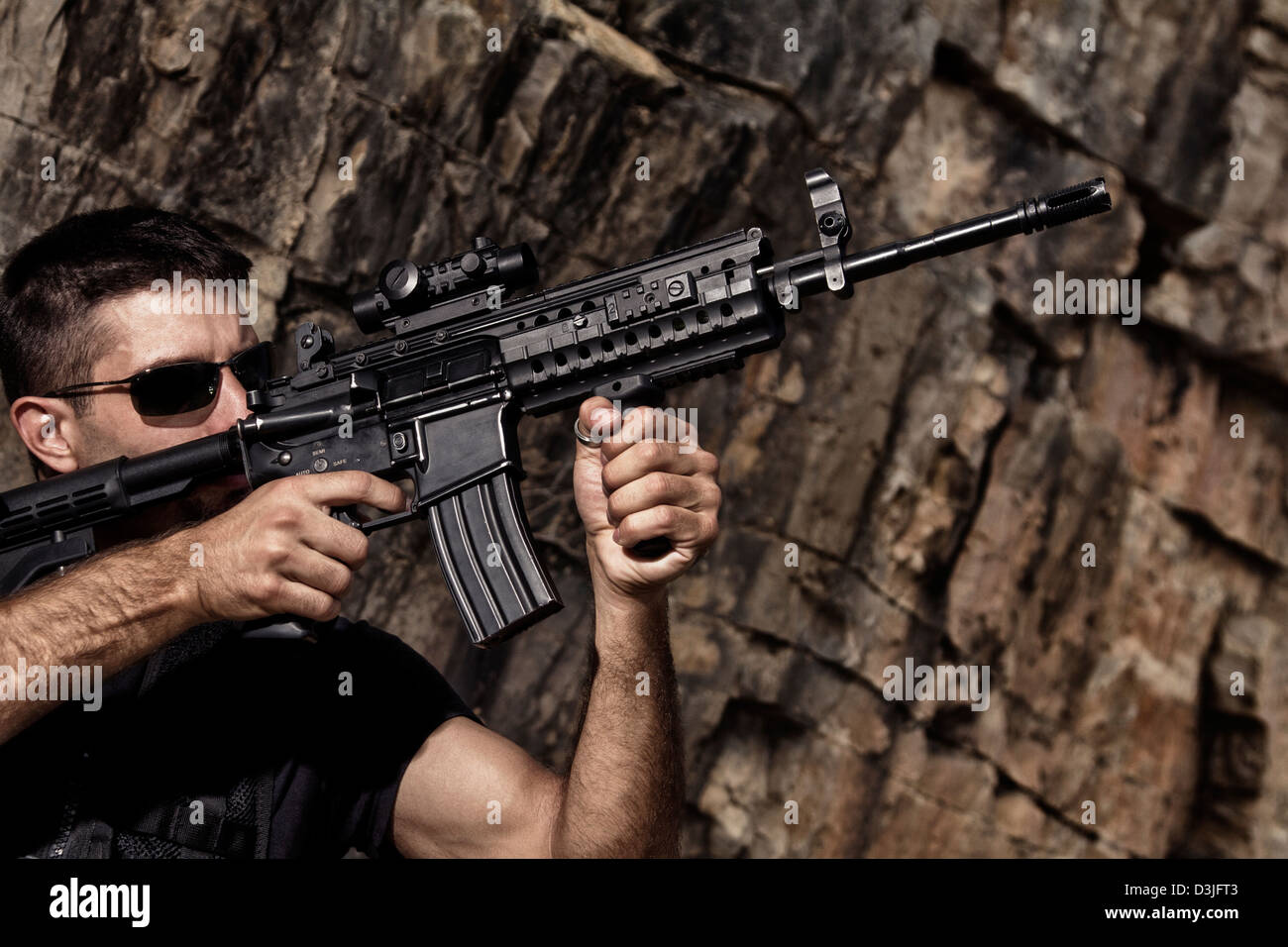 View of a menacing man pointing a machine gun in a black shirt and dark ...