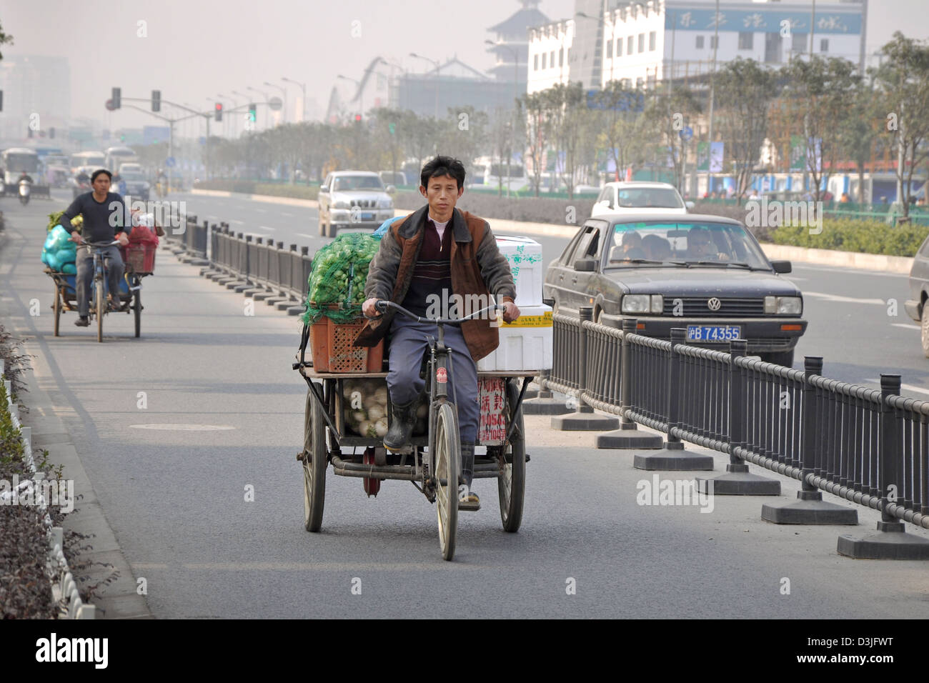 Chinese man riding a tricyle in a large street of Shanghai - China ...