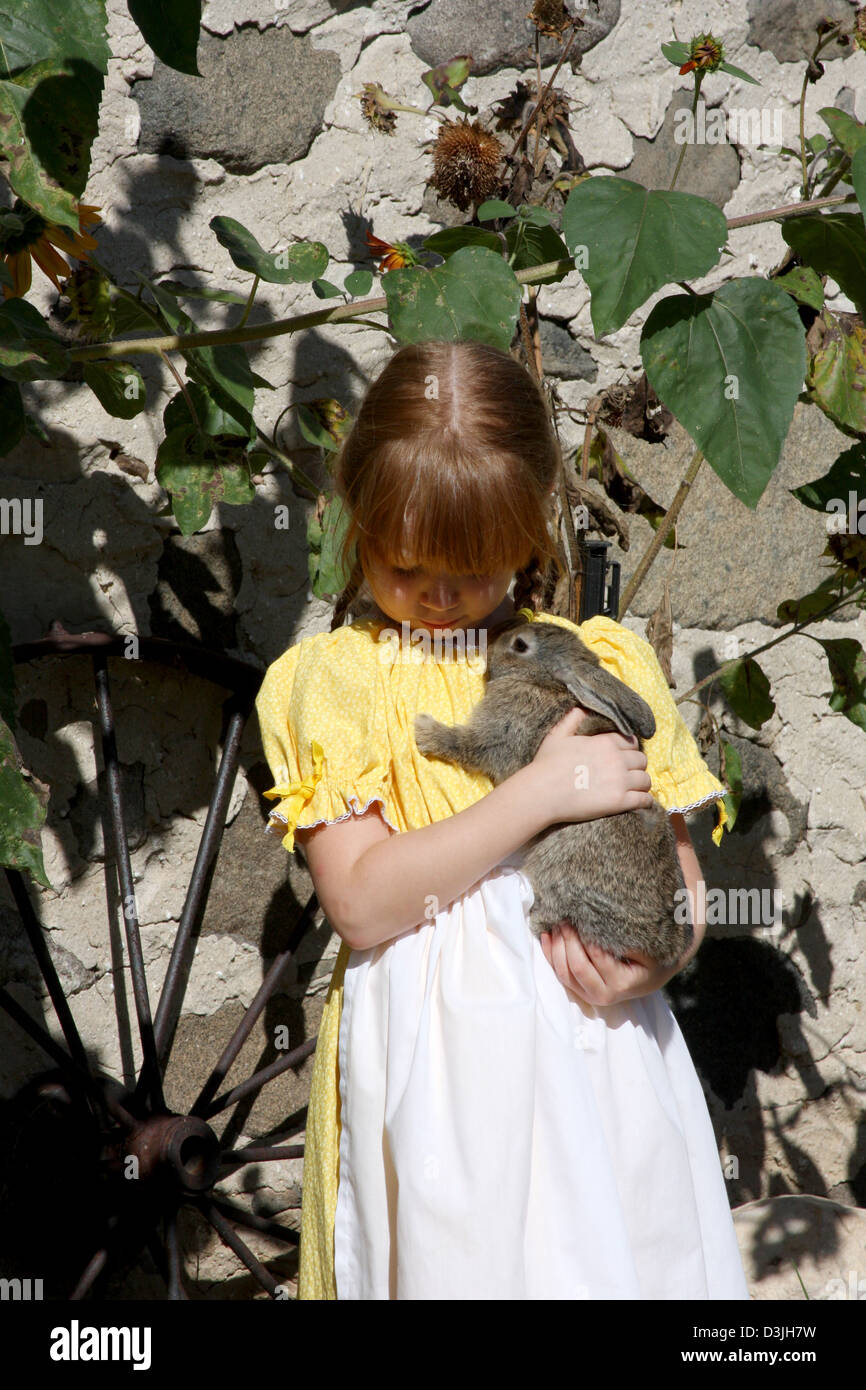 A young girl holding a bunny rabbit on a farm Stock Photo - Alamy