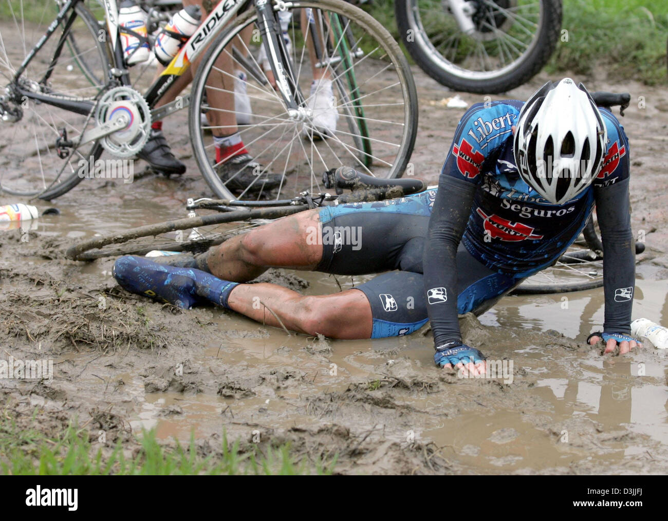 (dpa) - Spanish cyclist Allan Davis lies in dirty mud after a mass ...