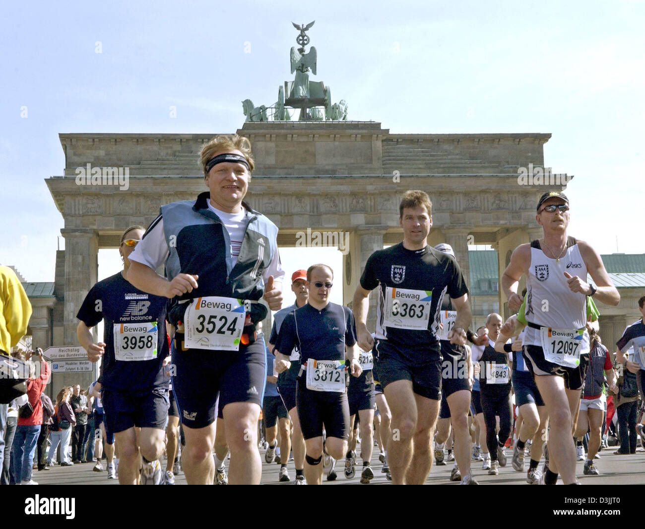 (dpa) - Participants of the Berlin Marathon run through the Brandenburg ...