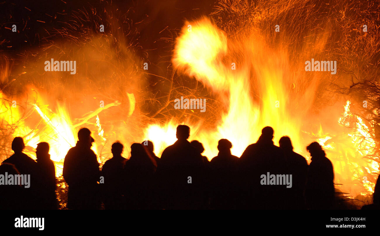 (dpa) - Dozens of spectators stand around a huge bonfire in ...