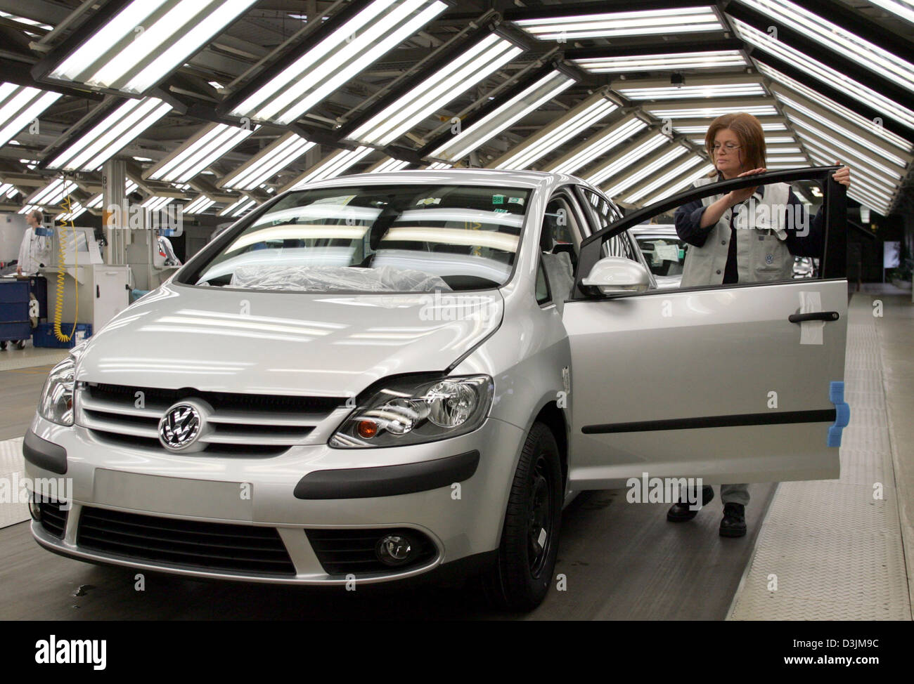 (dpa) - An employee (R) of Volkswagen (VW) conducts the final ...