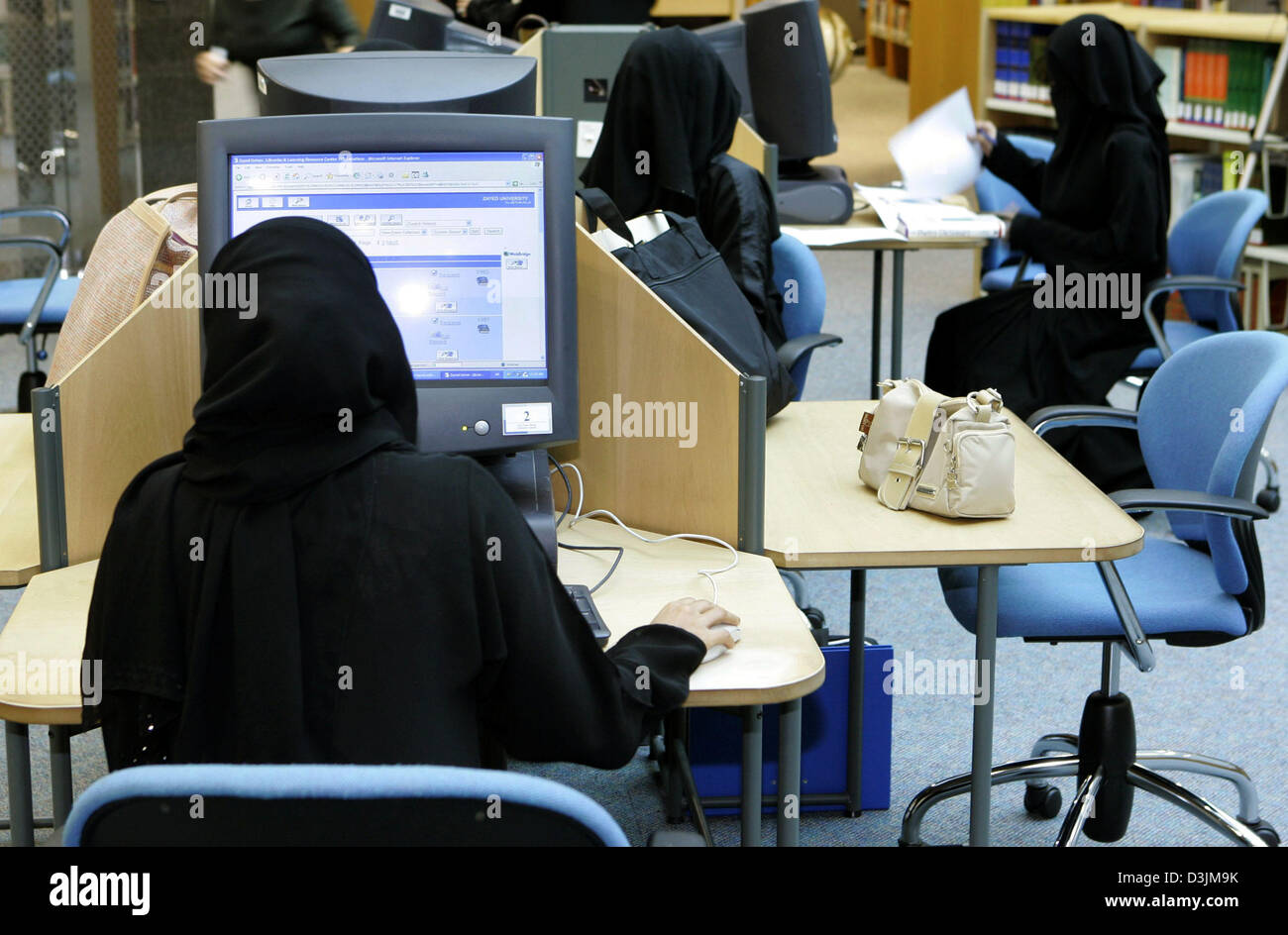 (dpa) - Women sit dressed in black clothes and veiled with scarves at ...