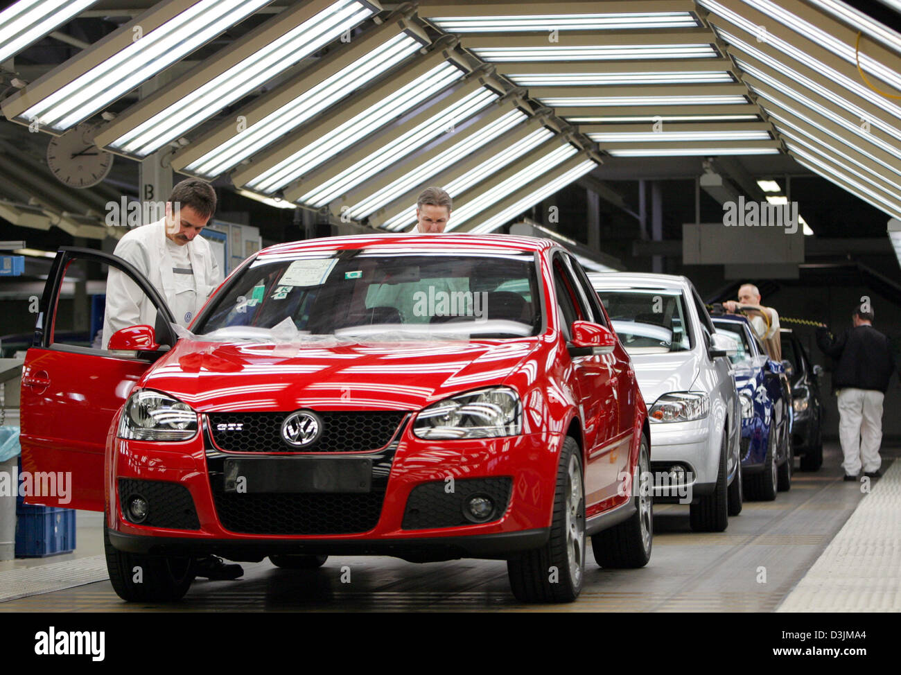(dpa) - Employee of Volkswagen (VW) inspect a series of Golf GTI at the ...