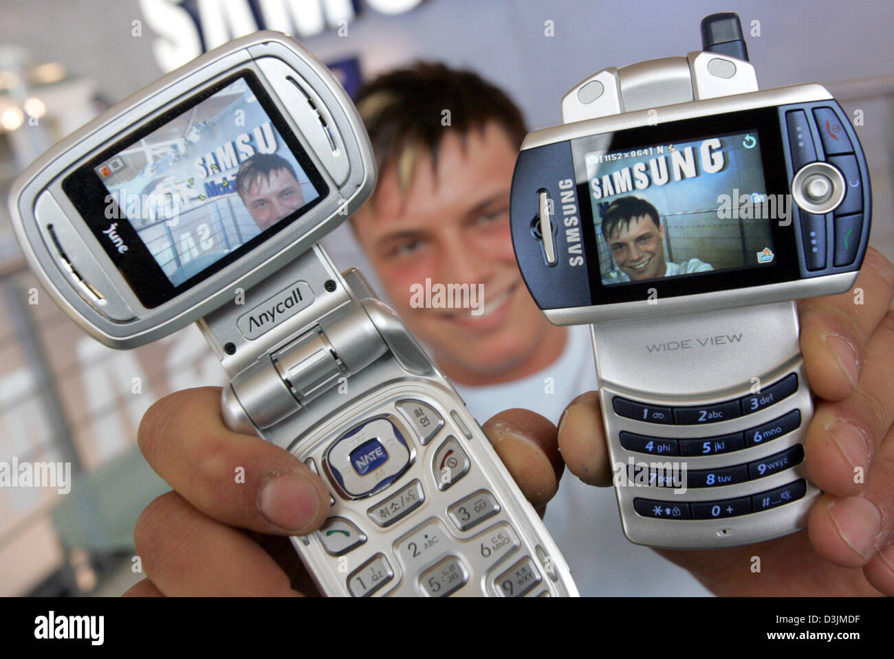 (dpa) - An employee presents the two new Samsung mobile phones SCH V 600 (L) and SHG-Z130 ...