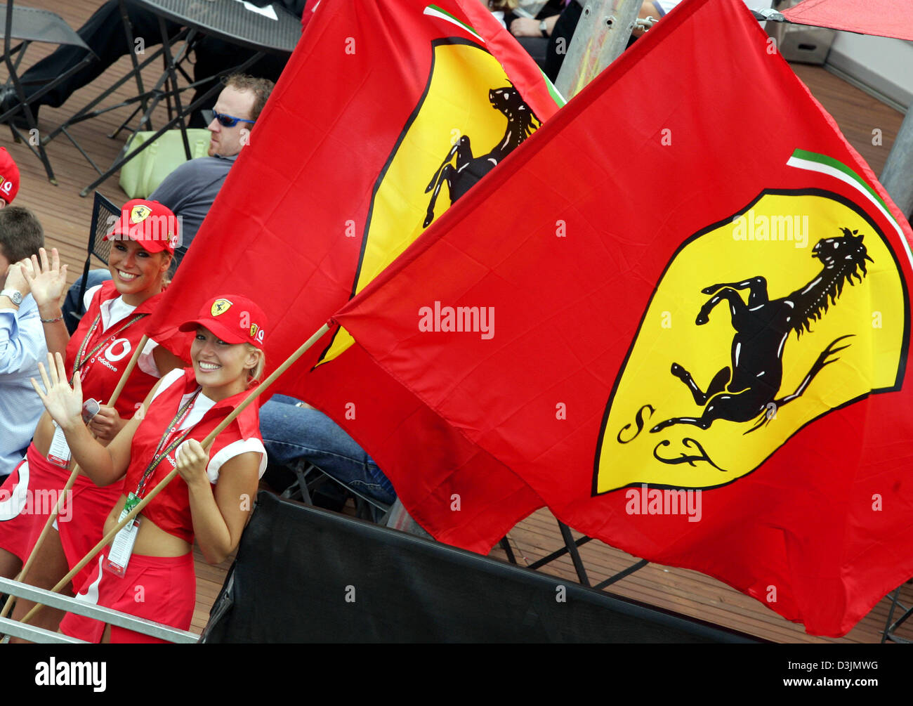 (dpa) - Two girls hold Ferrari flags during the first practice session ...