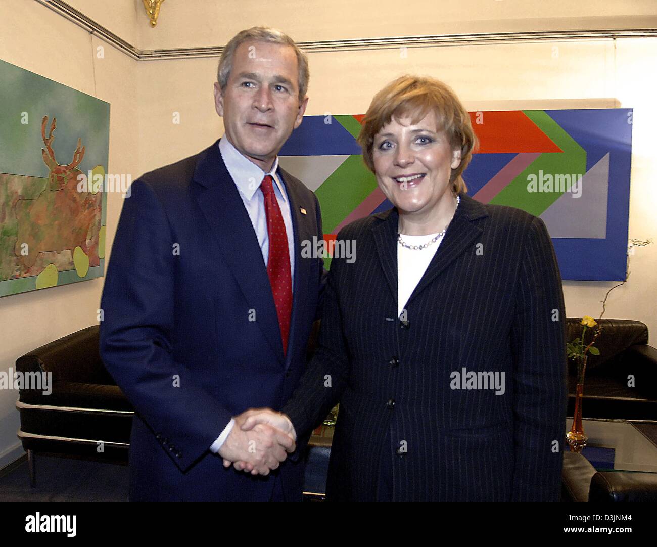 (dpa) - US President George W. Bush shakes hands with Angela Merkel ...