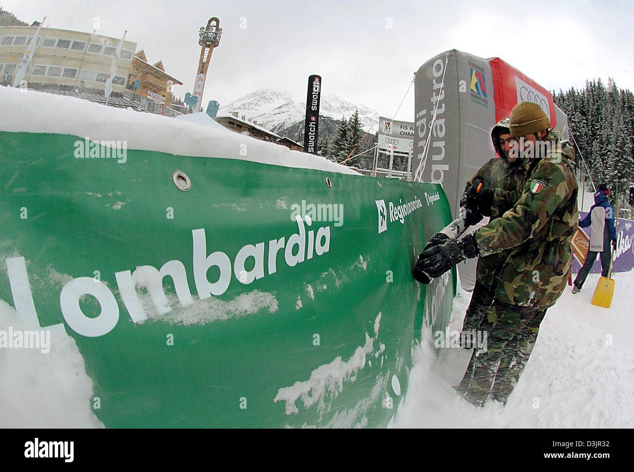 (dpa) - Italian soldiers blow away snow at the finishing area of the ...