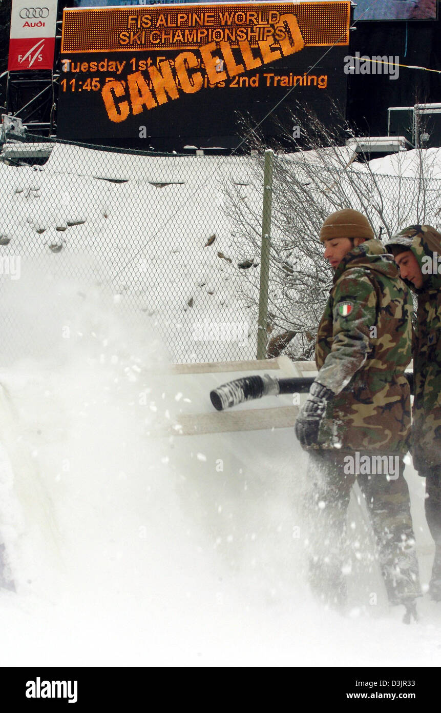 (dpa) - Italian soldiers blow away snow at the finishing area of the ...
