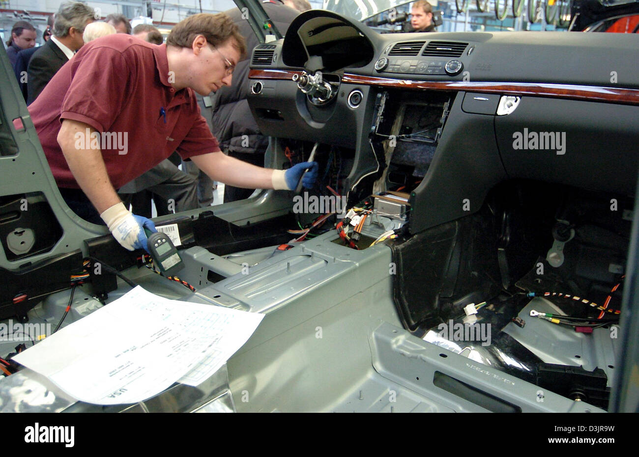(dpa) - A Mercedes employee works on the interior of a S-Class car at ...