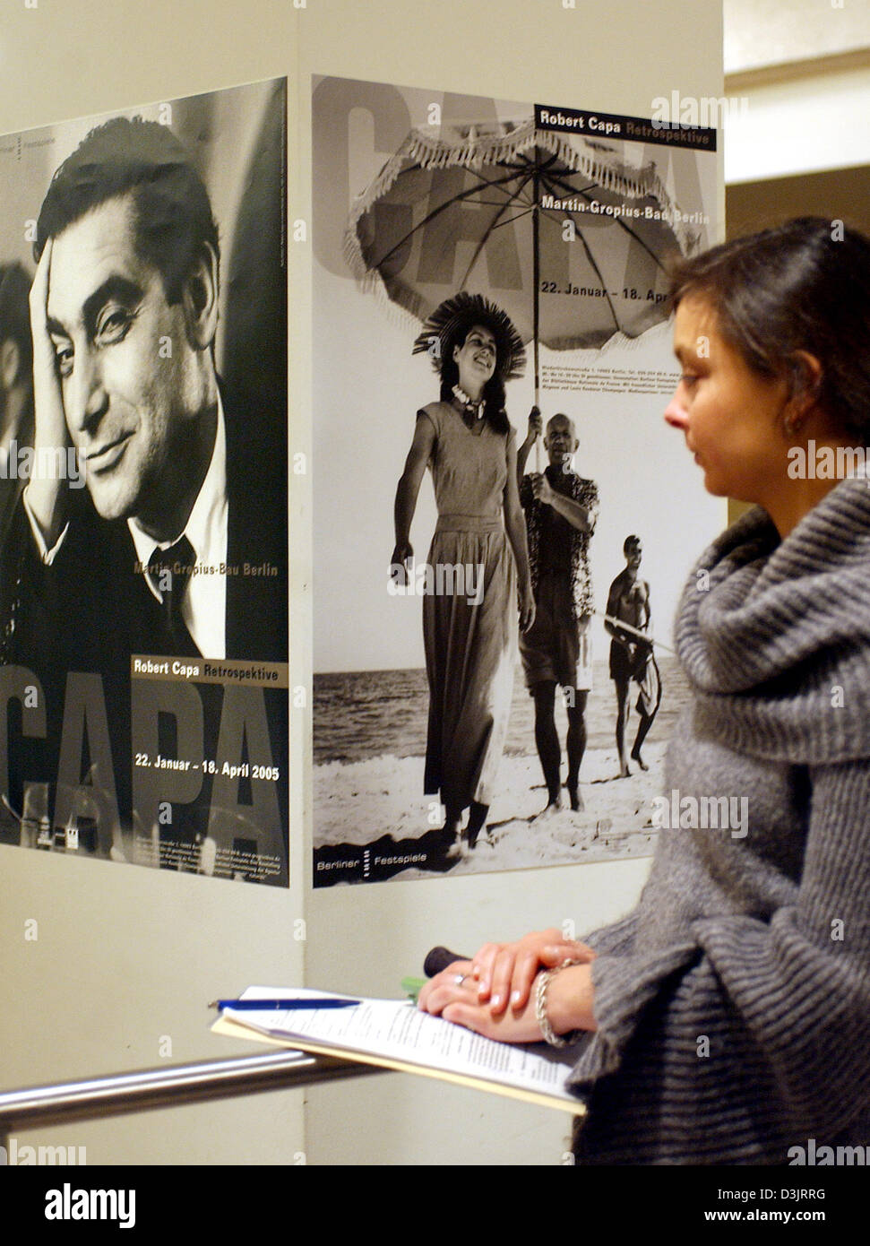 (dpa) - A visitor looks at two posters (left a portrait of Robert Capa ...