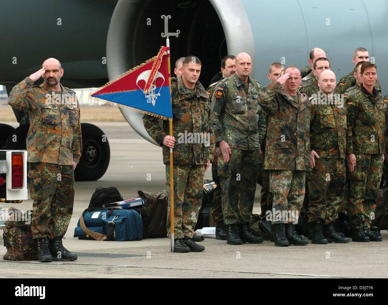 (dpa) - Paramedics and doctors of the German army hold the flag of ...
