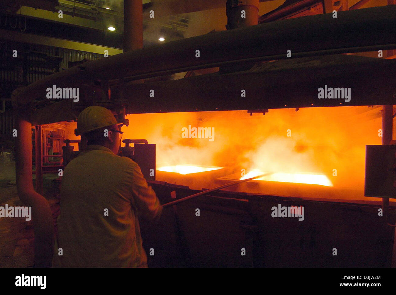 (dpa) - A worker uses a long pole to test liquid copper on the factory ...