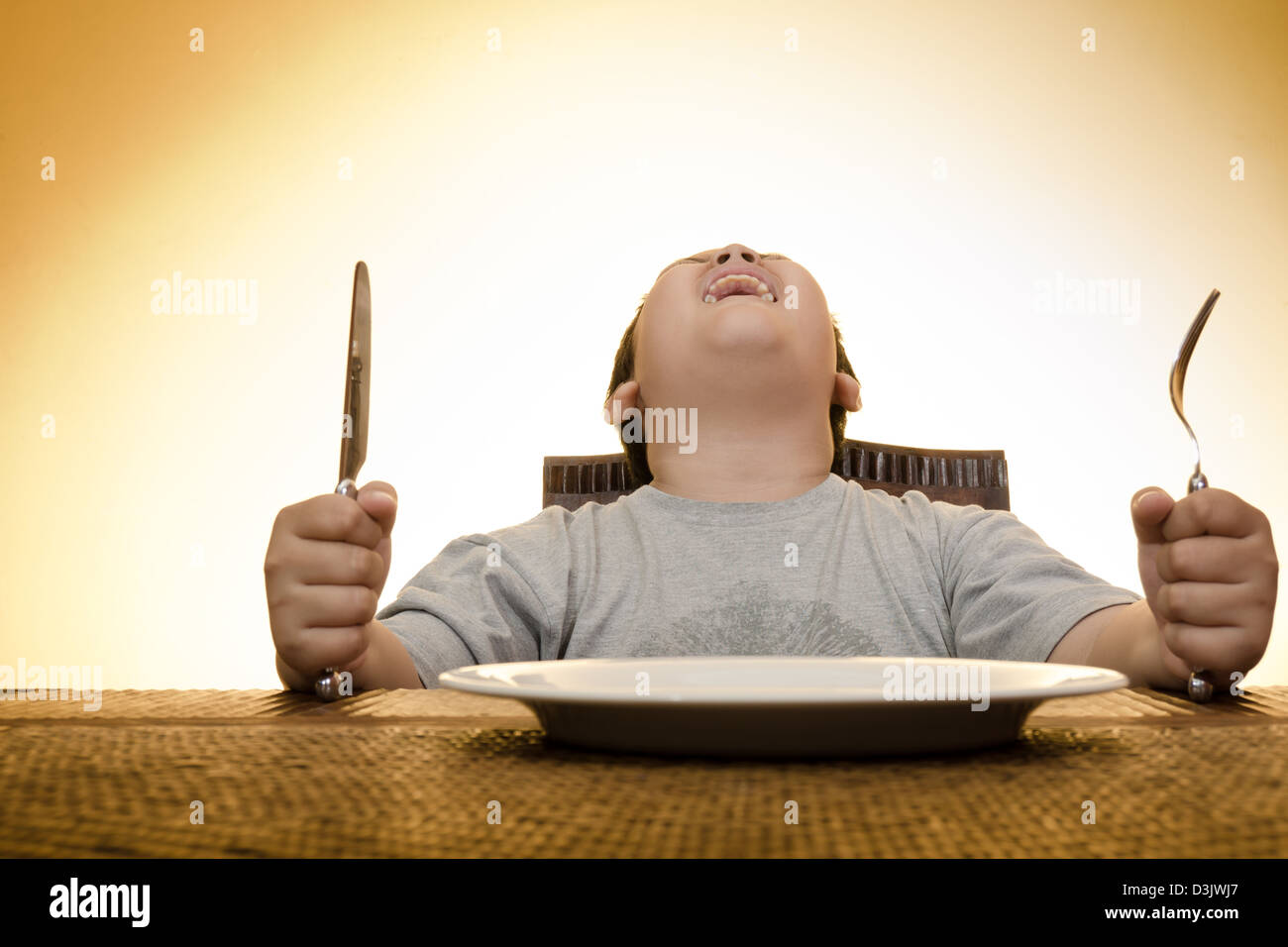 asian boy screaming on dining table waiting for food Stock Photo - Alamy