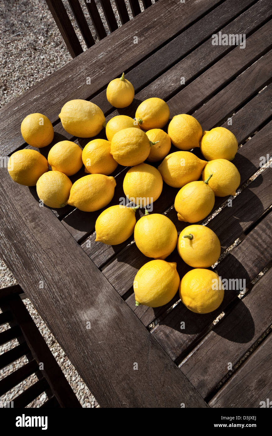 some lemons resting on a wooden table Stock Photo - Alamy