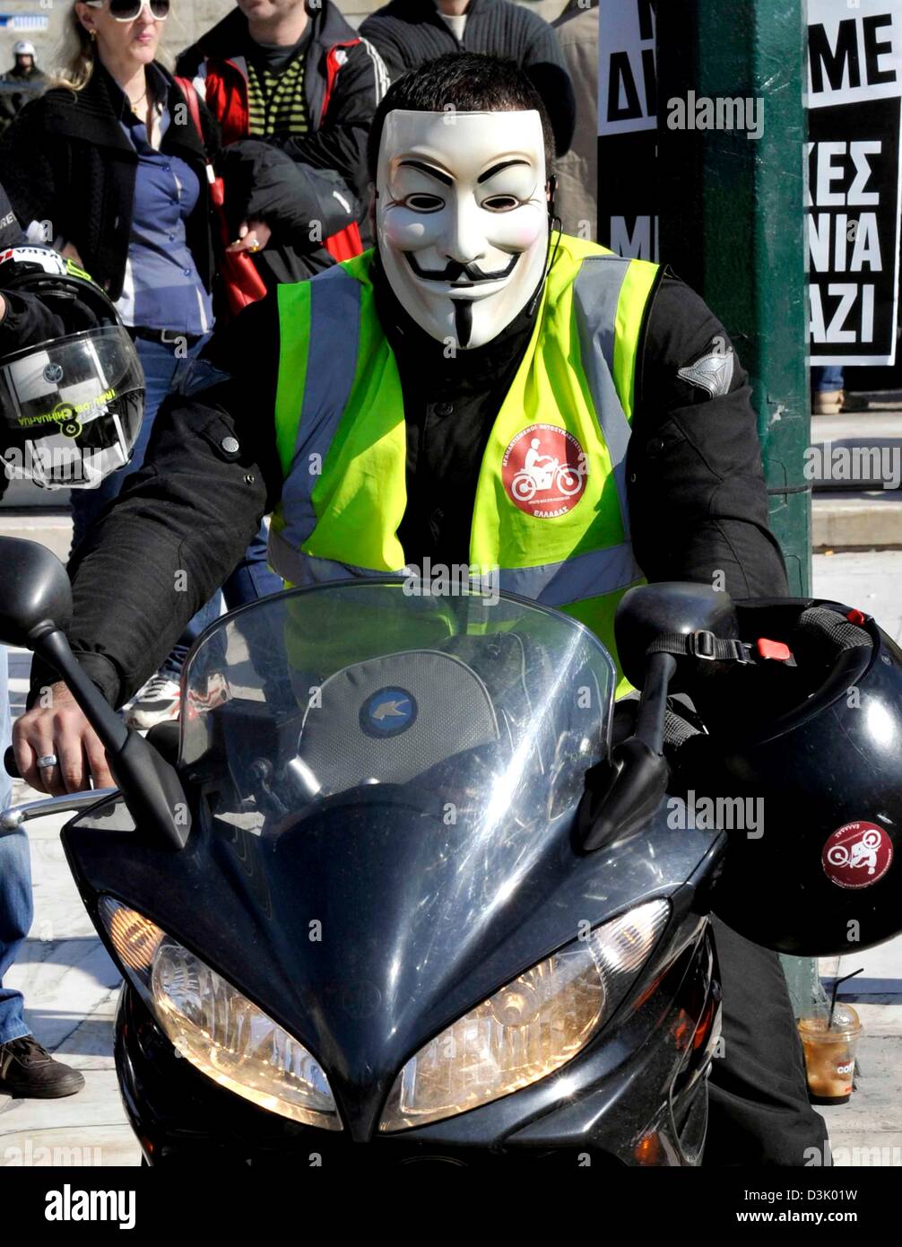 A man on a motorcycle wears a Guy Fawkes mask during a general strike ...
