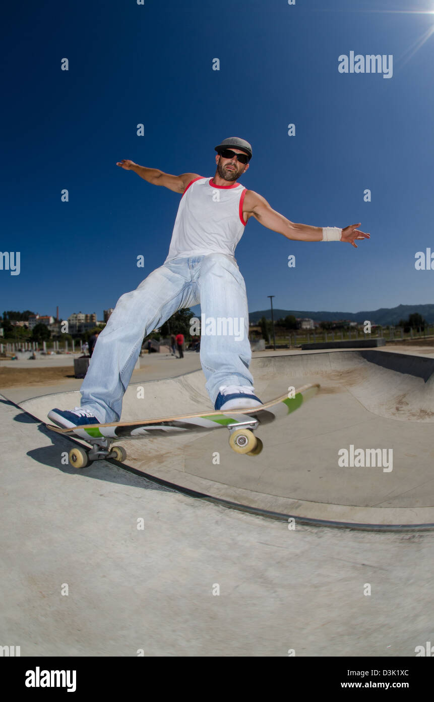 Skateboarder in a concrete pool at skatepark on a sunny day Stock Photo ...