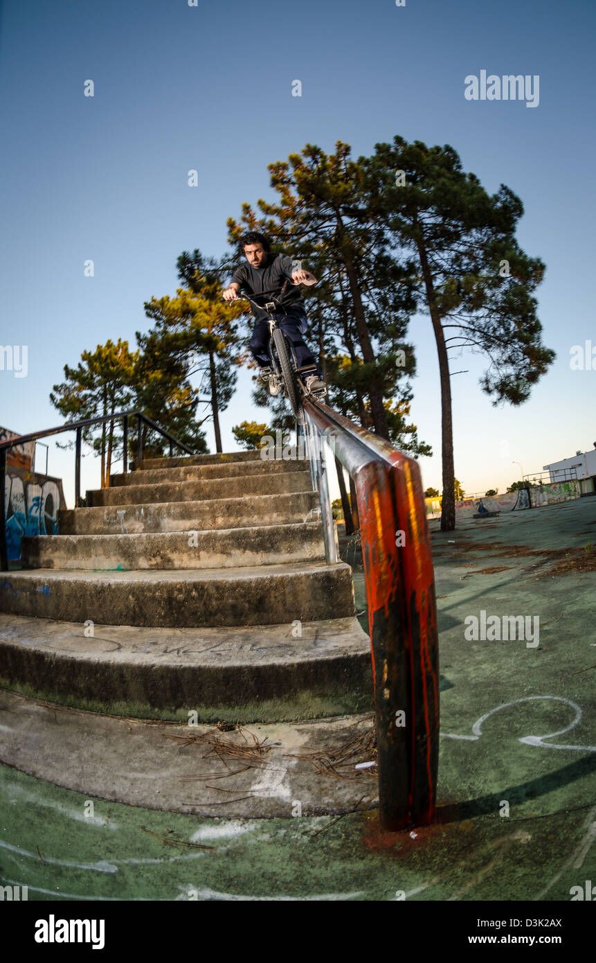 Biker doing peg grind down the hand rail over the stairs Stock Photo ...