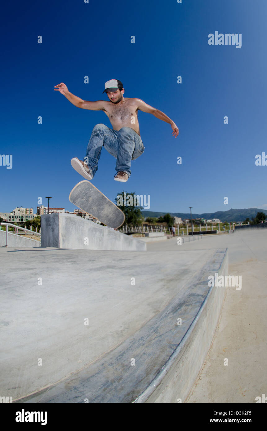 Skateboarder on a flip trick at the local skatepark Stock Photo - Alamy