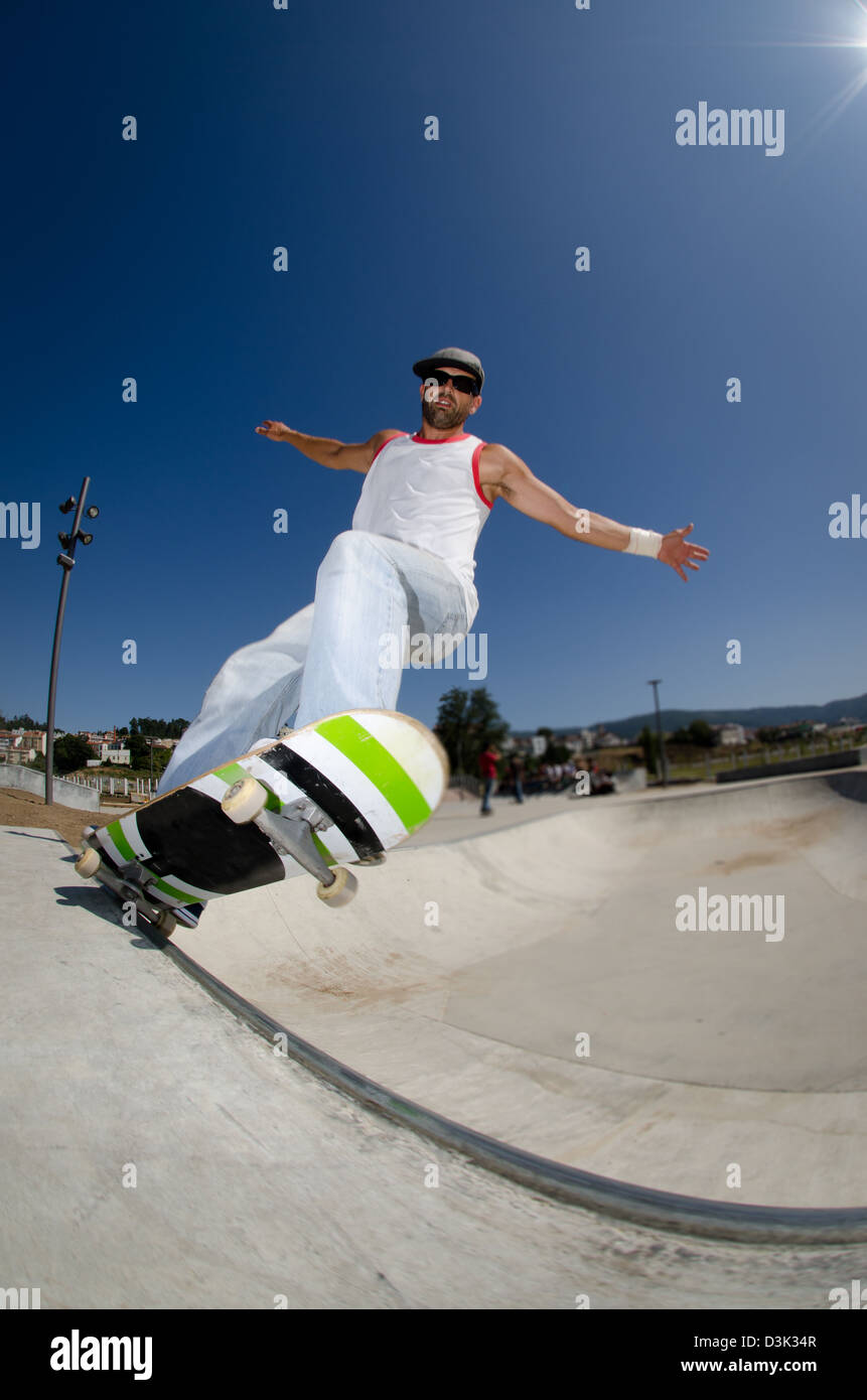 Skateboarder in a concrete pool at skatepark on a sunny day Stock Photo ...