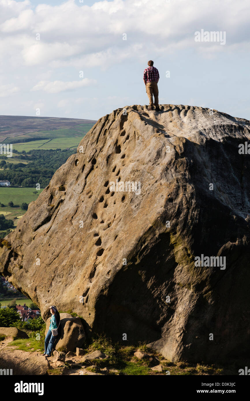 A man on top of the Cow and Calf rocks looks over the view towards ...