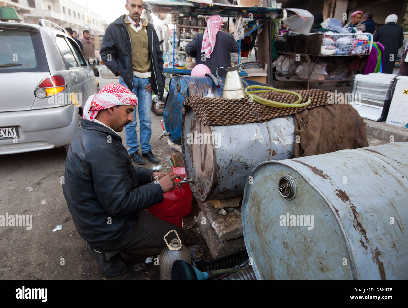 Aleppo, Syria: A man fills up a gasoline container at a roadside gas ...