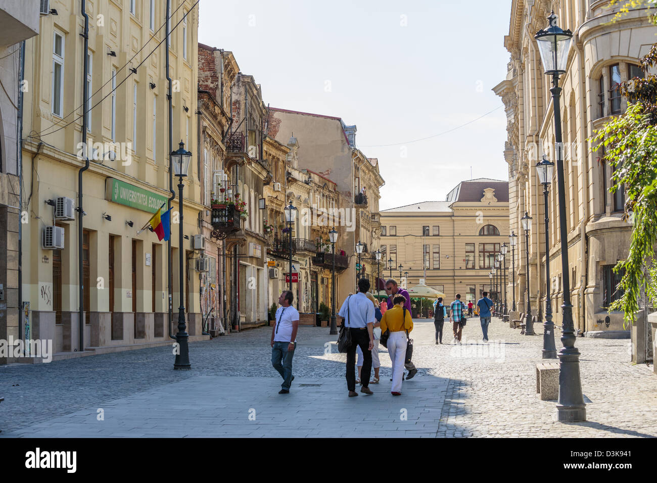 Group of tourists stroll down the cobblestone streets of the old ...