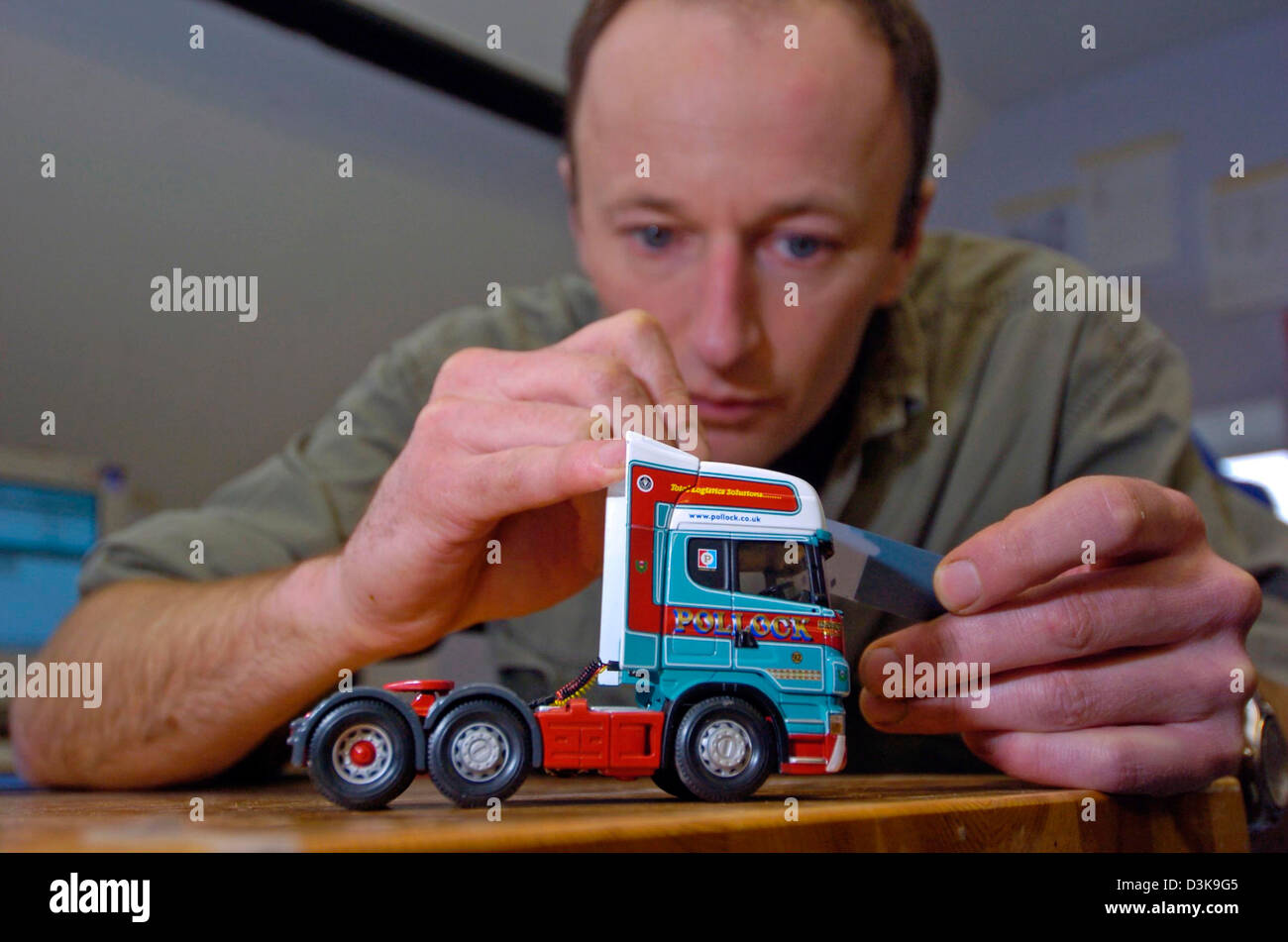 Man painting a toy lorry Stock Photo - Alamy