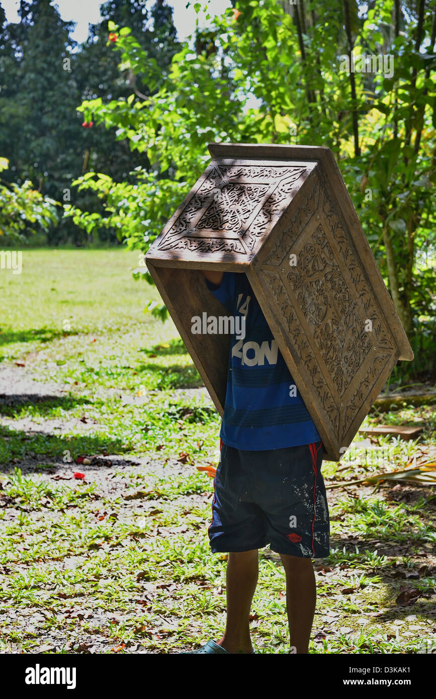 A native boy carrying an antique carved wooden box Stock Photo - Alamy