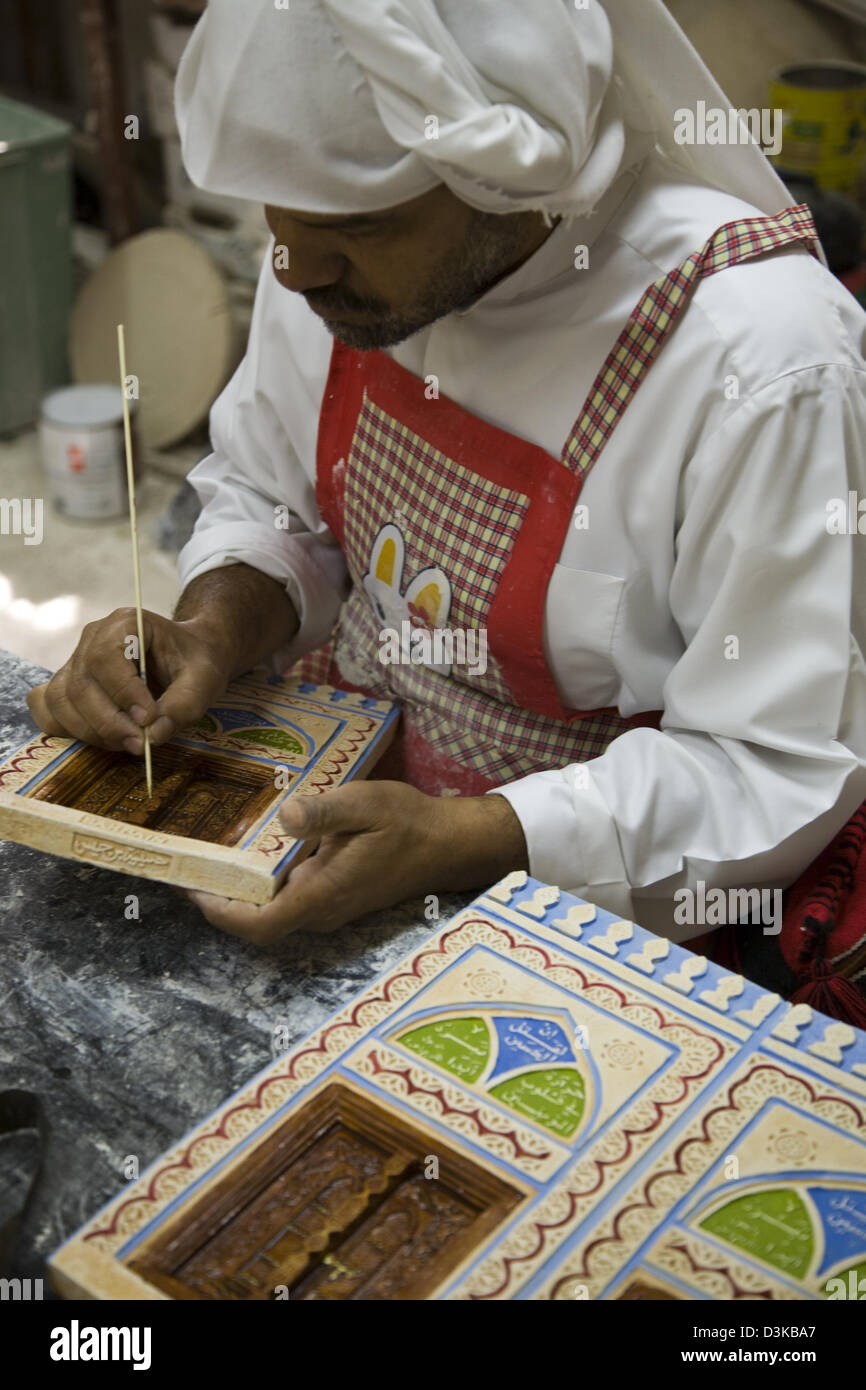 This craftsman engraves and paints gypsum slabs at Al-Jasara Handicraft ...
