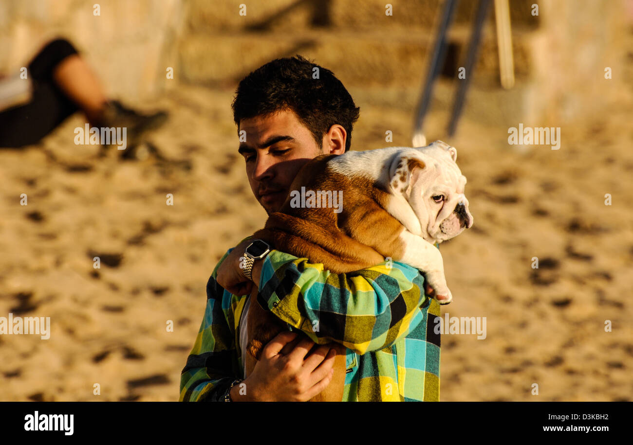 A man carrying his cute dog Stock Photo - Alamy