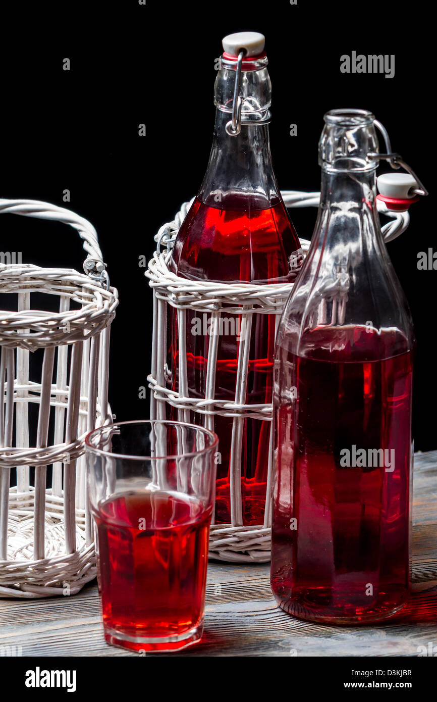 Old bottles in basket with red juice Stock Photo - Alamy