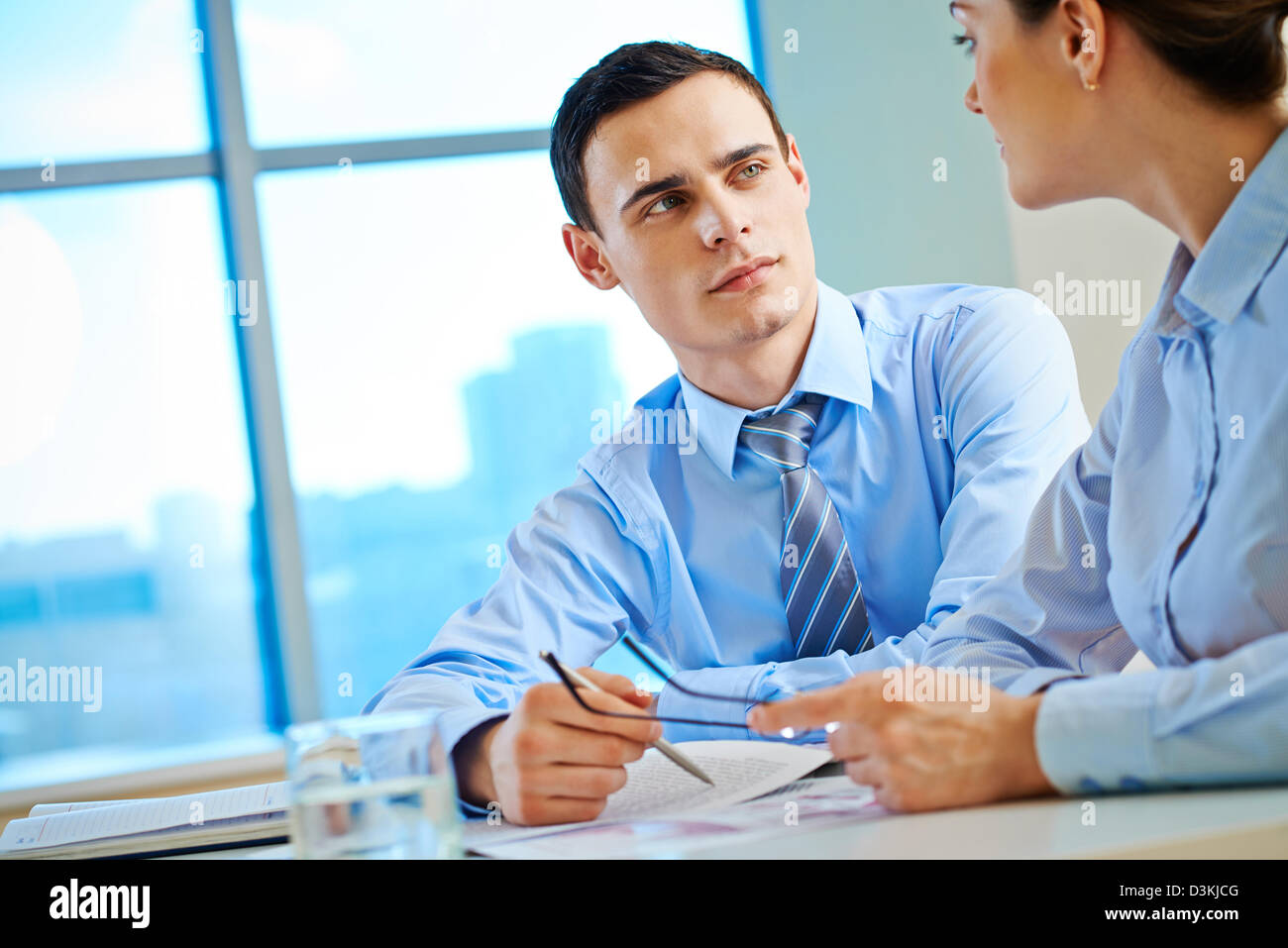 Business partners discussing papers and planning work at meeting Stock ...