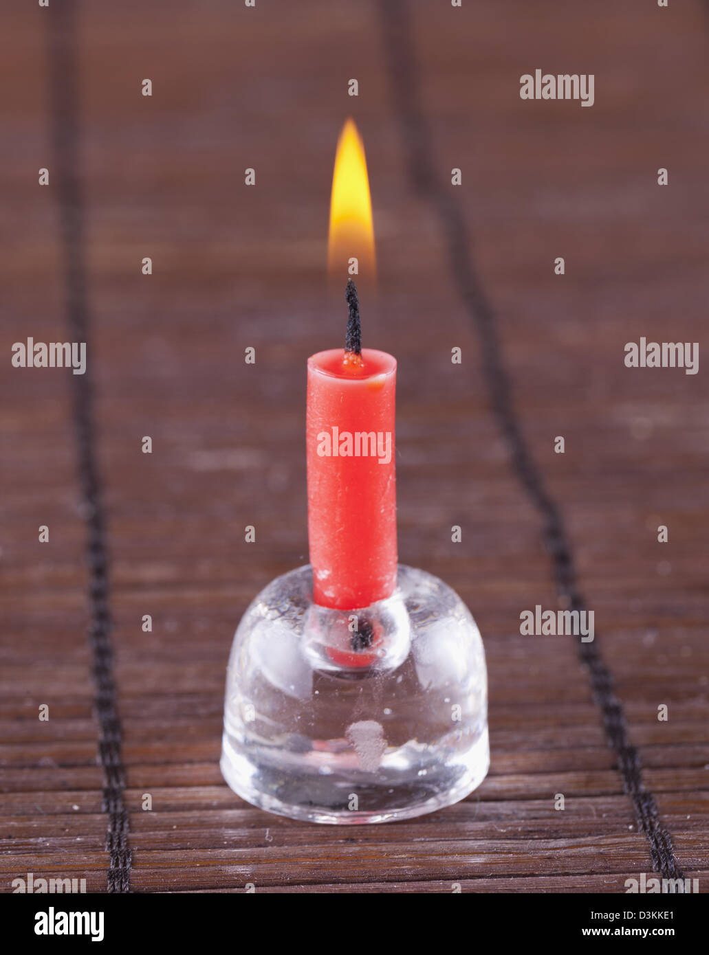 Little red candle over wooden mat background Stock Photo - Alamy