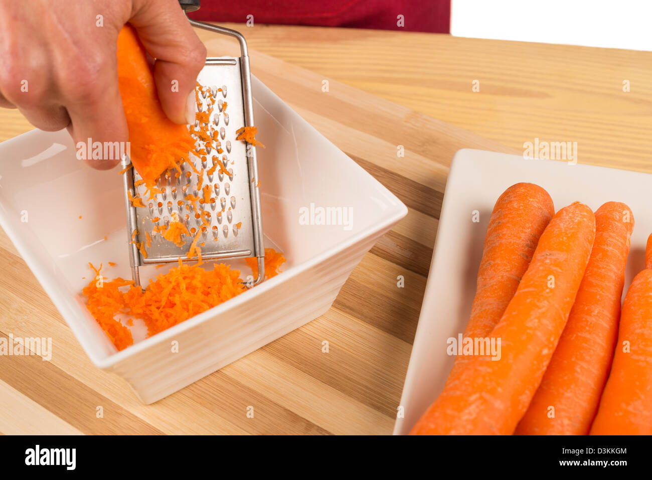 Grating freshly peeled carrots for a salad Stock Photo - Alamy
