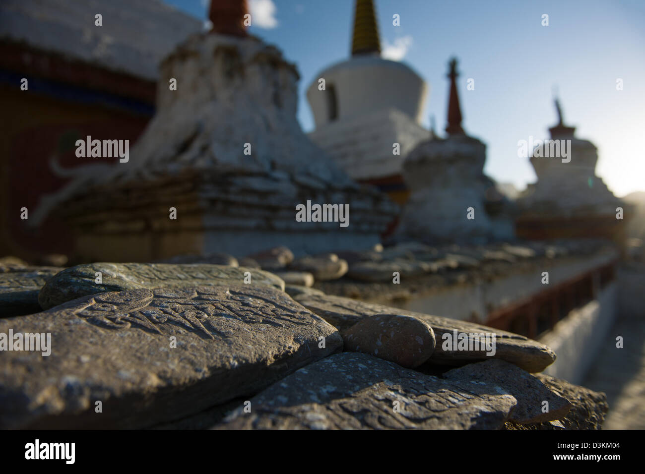 Mani Stone carved with Tibetan Script, in front of funerary stupas ...