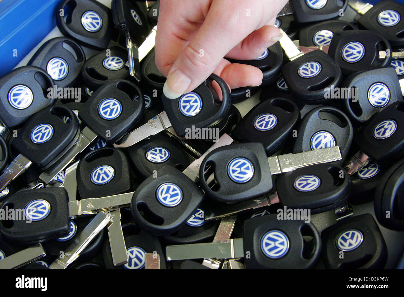 (dpa) - A hand takes a key from a pile of brand new ignition keys ...