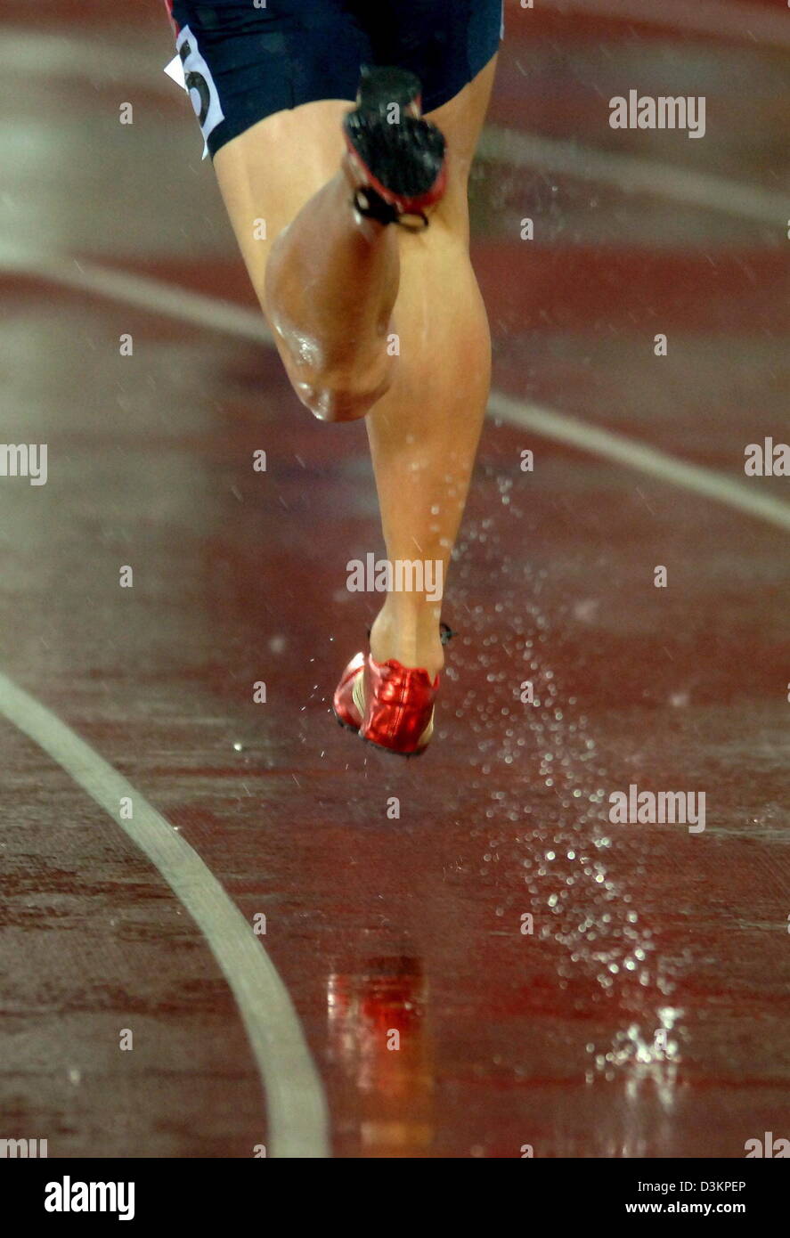 (dpa) - An athlete runs in the rain on the wet track in the 400m sprint ...