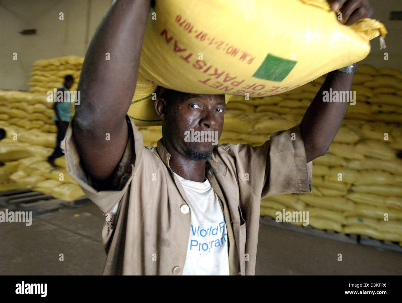 (dpa) - A World Food Programme (WFP) volunteer carries a sack of grain ...