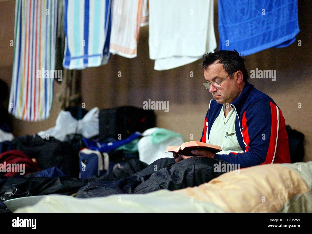(dpa) - Hungarian priest Taksies Ahejes sits between sleeping fellow ...