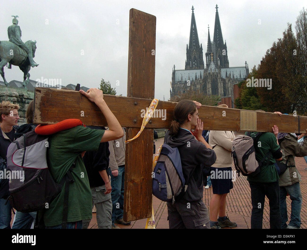 (dpa) - Pilgrims carry a symbolic cross through the city of Cologne ...
