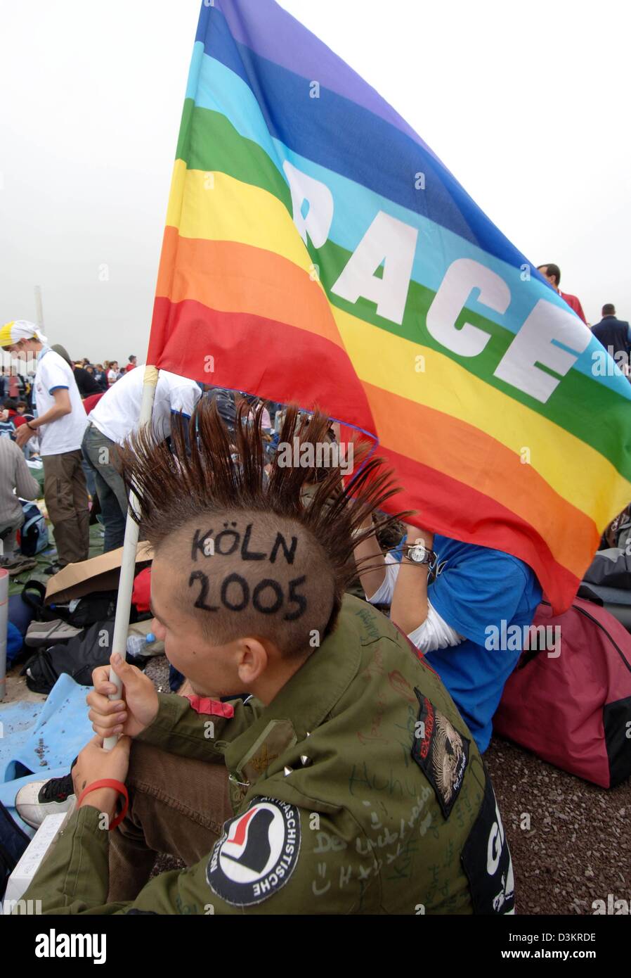 (dpa) - A pilgrim sporting a punk hairstyle, holds a peace flag in his ...