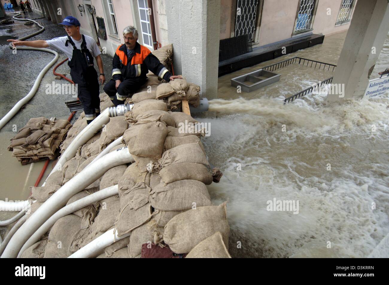 (dpa) - Two firefighter s stand on a dam erected for protection against ...