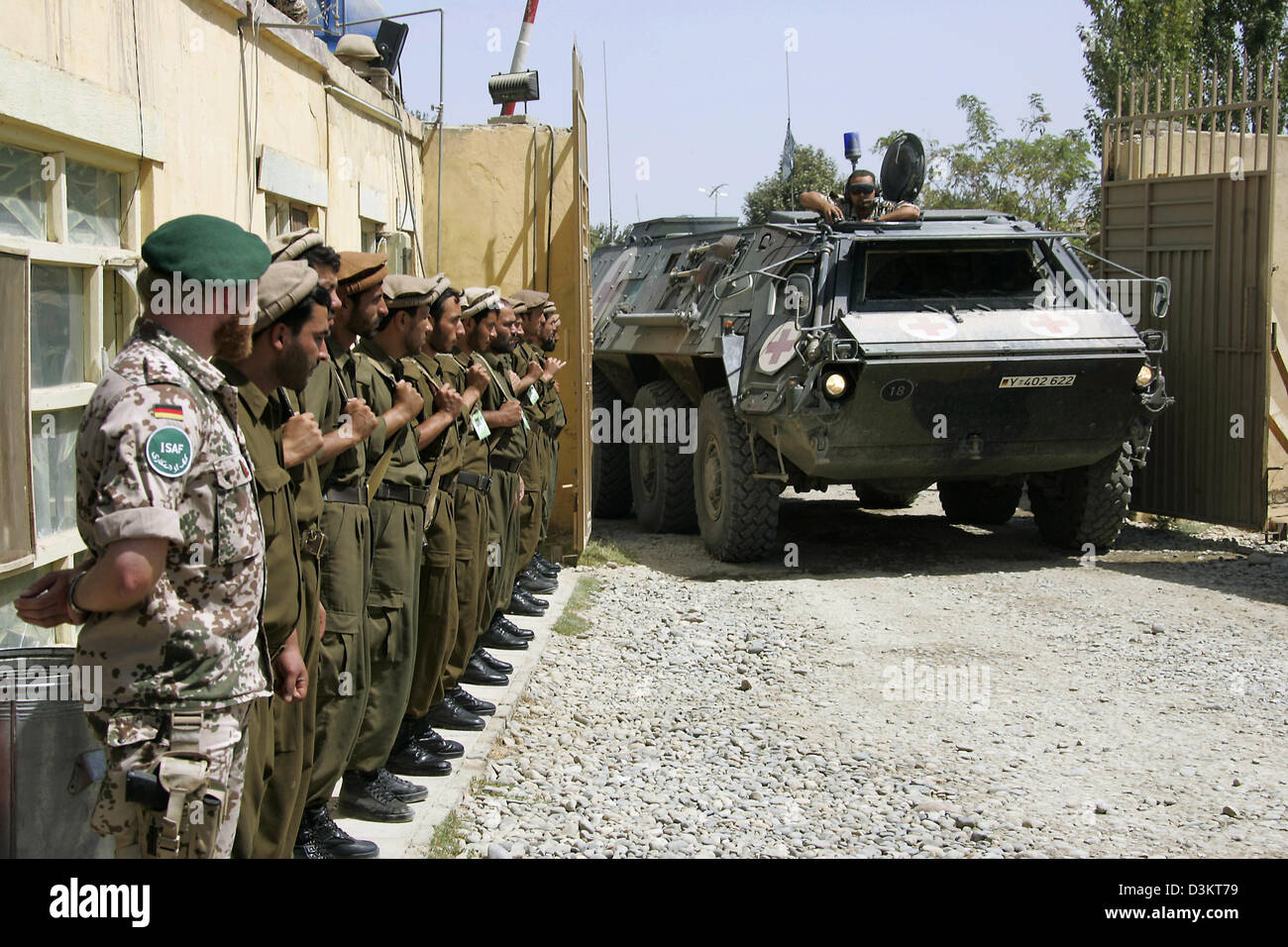 (dpa) - A German soldier (L) and several Afghan soldiers stand still at ...