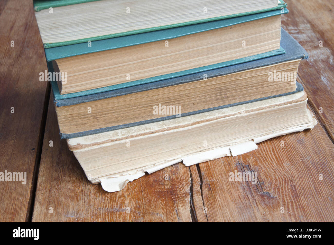 angle view to stack of old books laying on the vintage wooden tabletop ...